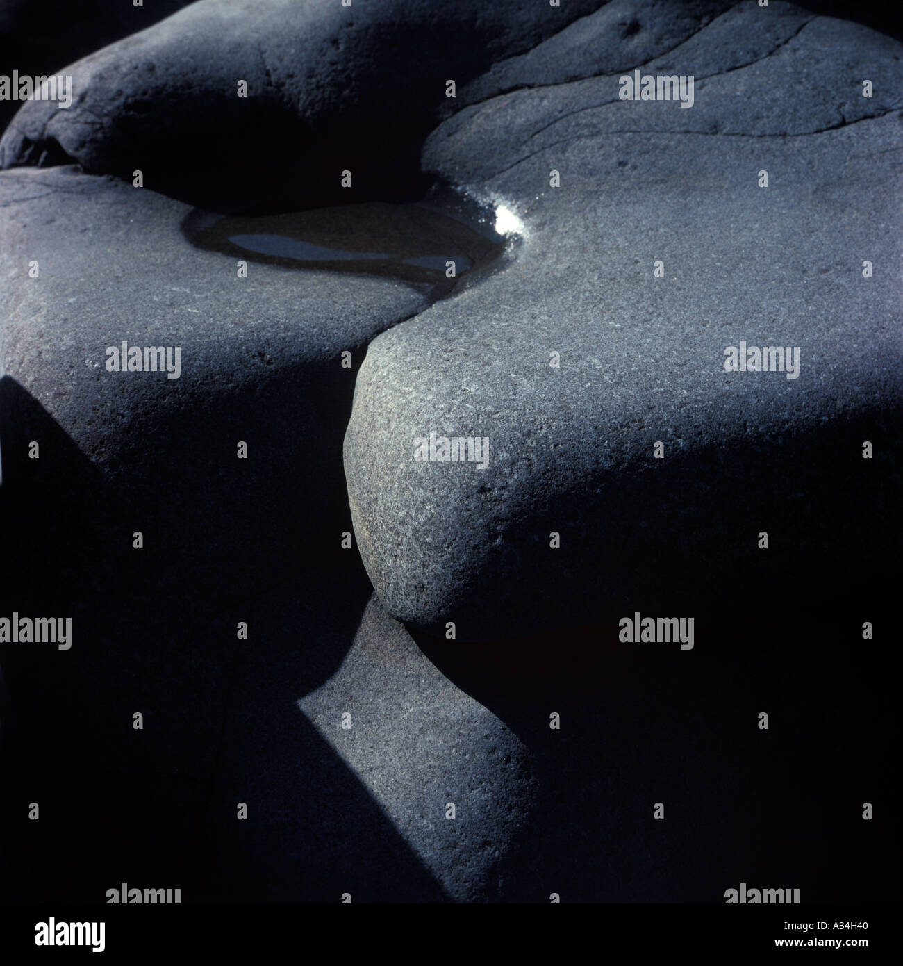 Rockpool in curvaceous dark rock formation foreshore Duckpool North ...