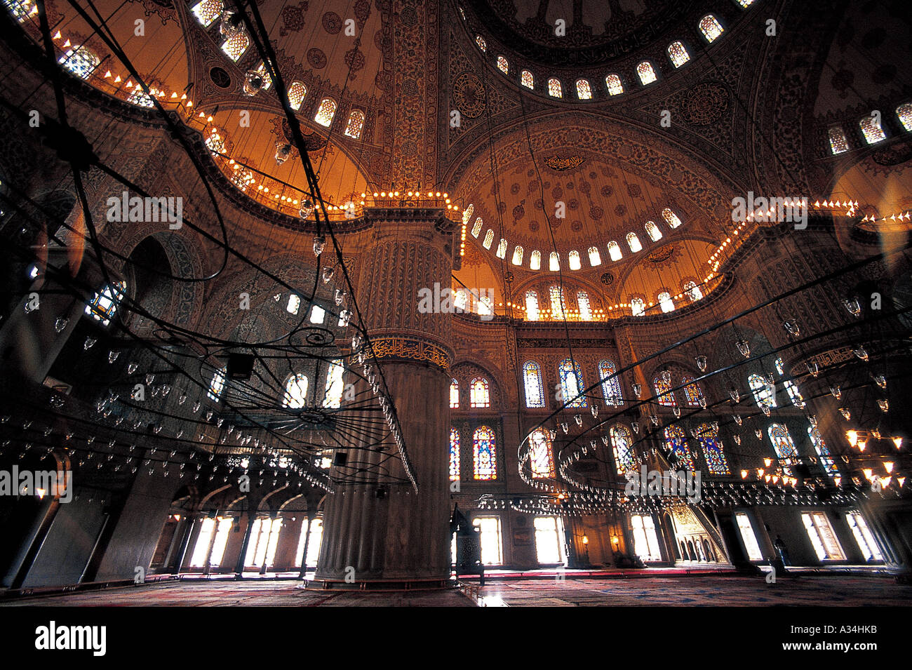 A view of the inside of an Islamic temple with huge lighting features ...
