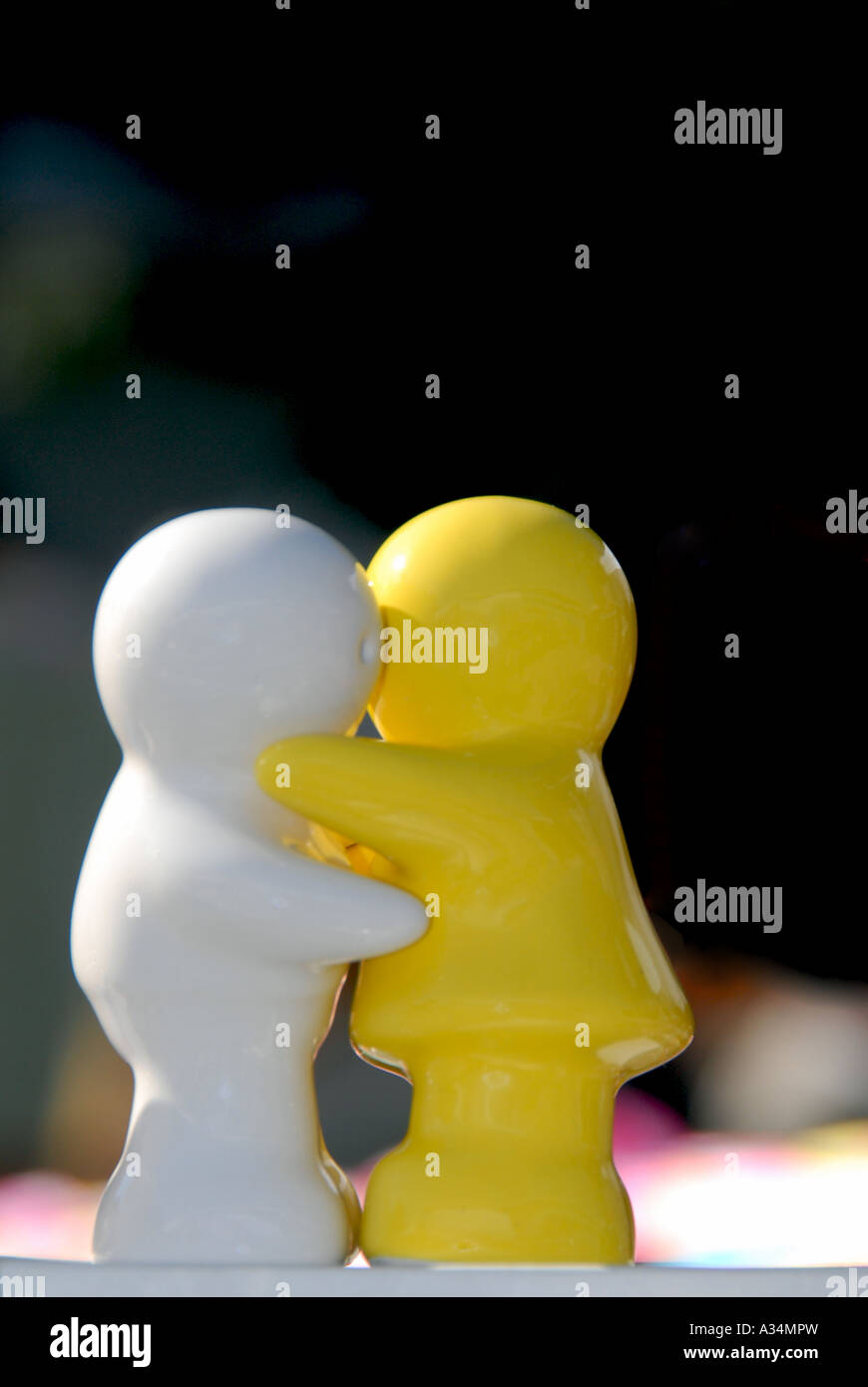 One yellow and one white human looking figurines hugging Stock Photo ...