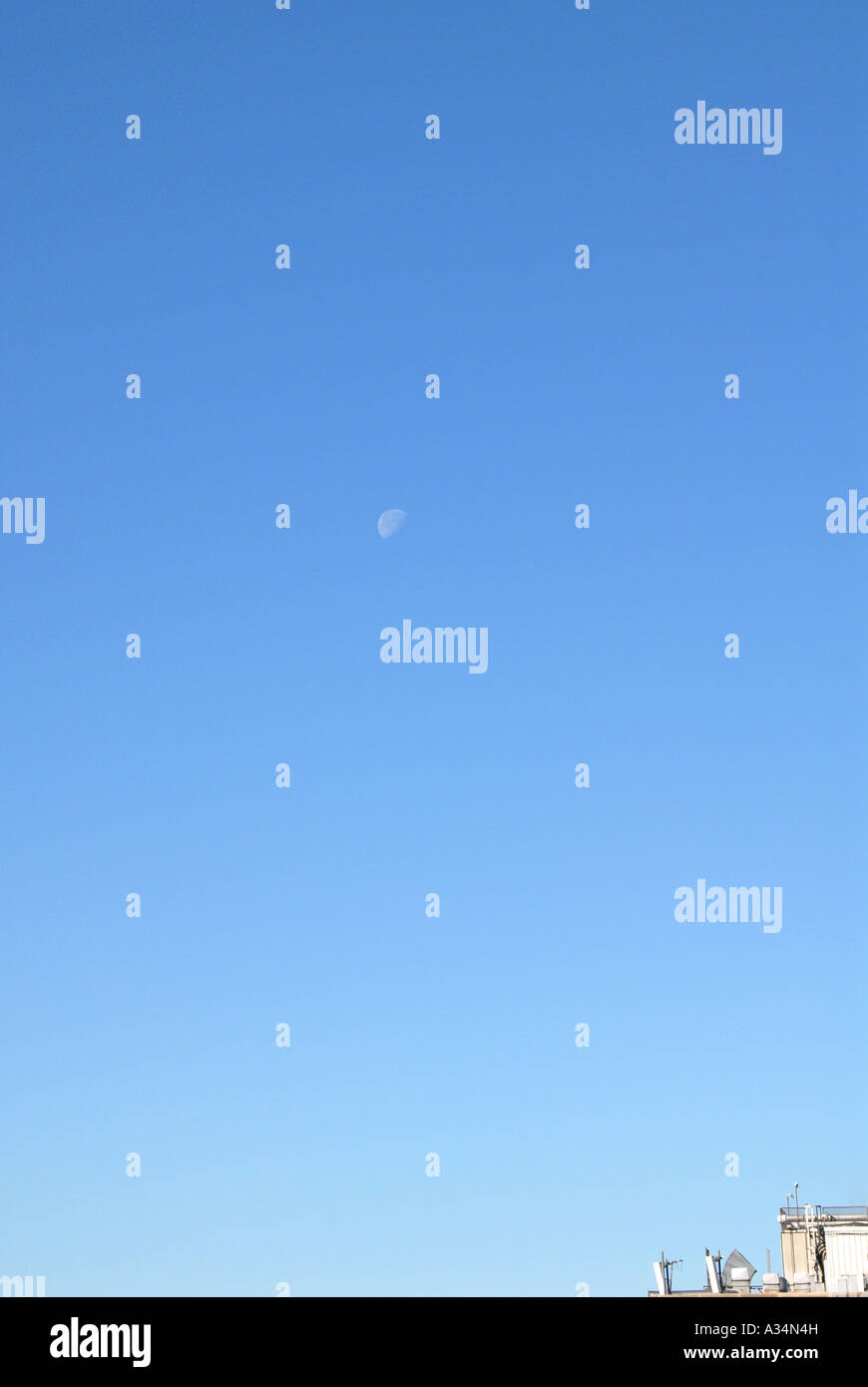Pale moon in morning high rise building tops in lower corner Stock ...