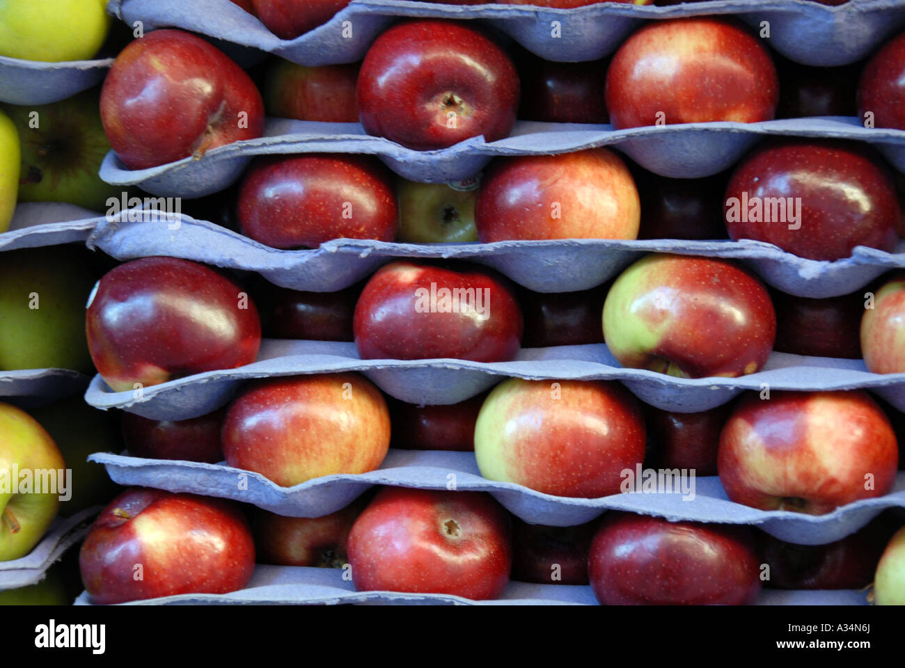 Red apples stacked between blue packaging layers Stock Photo - Alamy