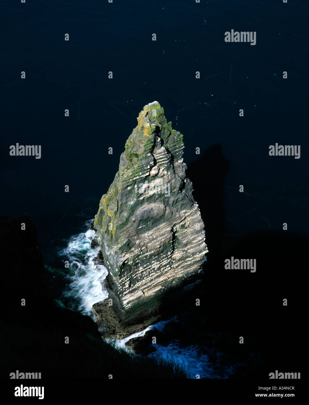 detached sea stack sits forlorn in the atlantic ocean off the cliffs of ...