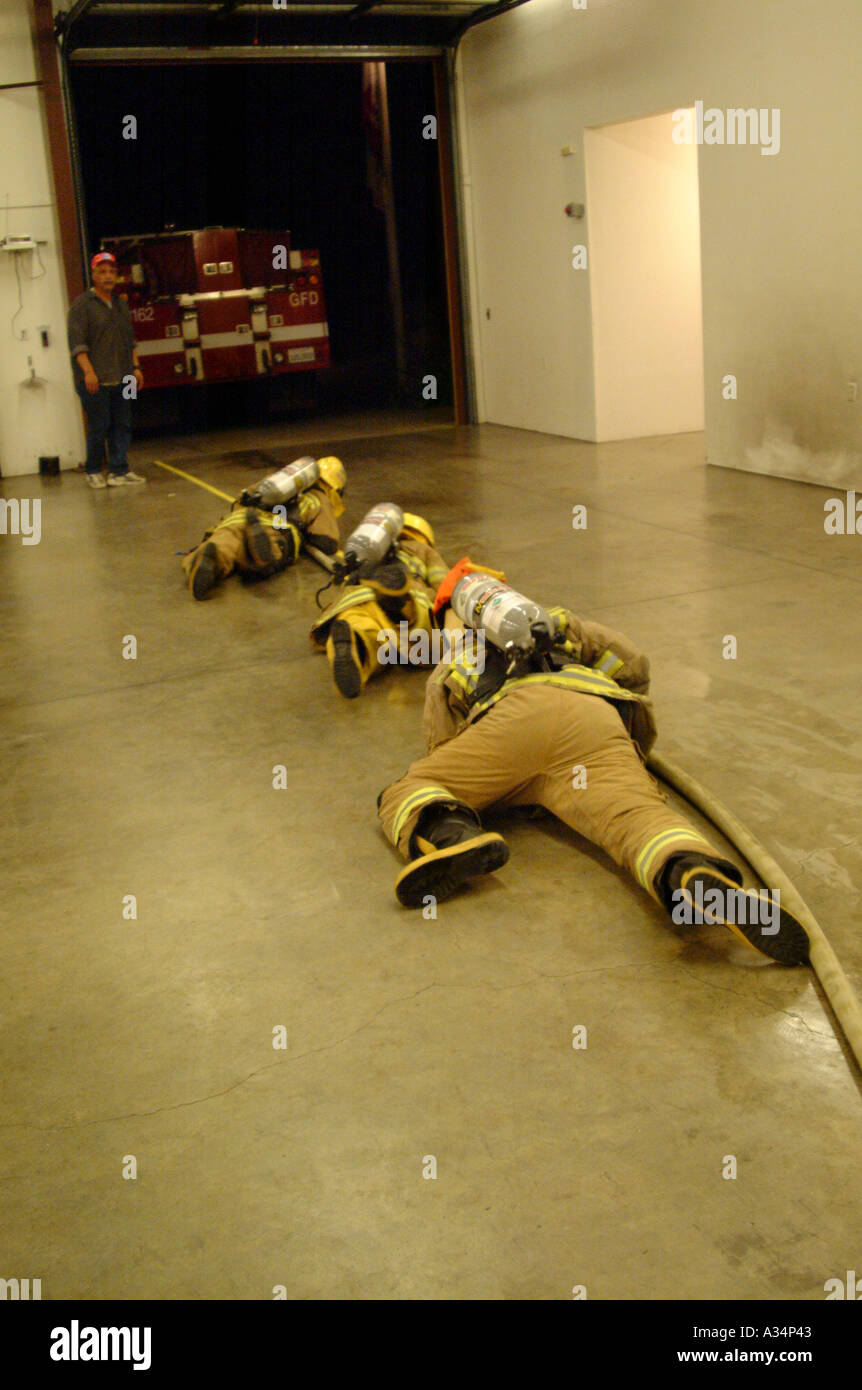 Firefighter trainees practice their skills by pulling a hoseline ...