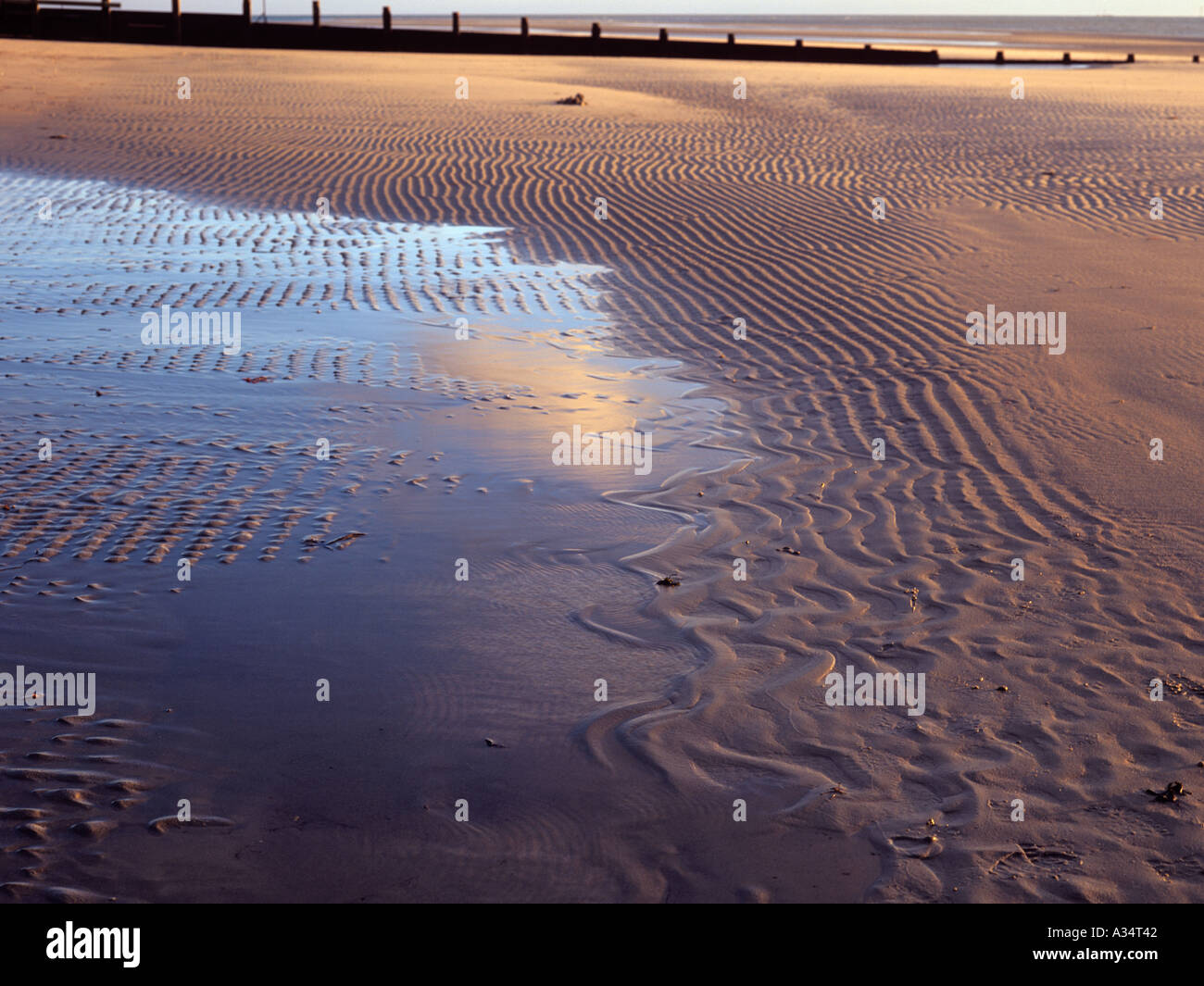 Sand ripple patterns and tidal pool at low tide on empty beach Stock ...