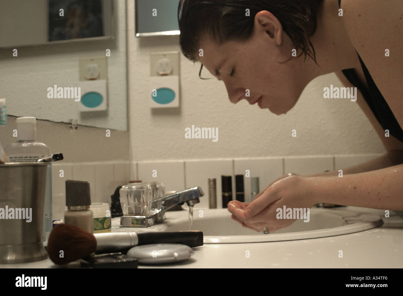 thirty year old woman washing makeup off her face Stock Photo - Alamy