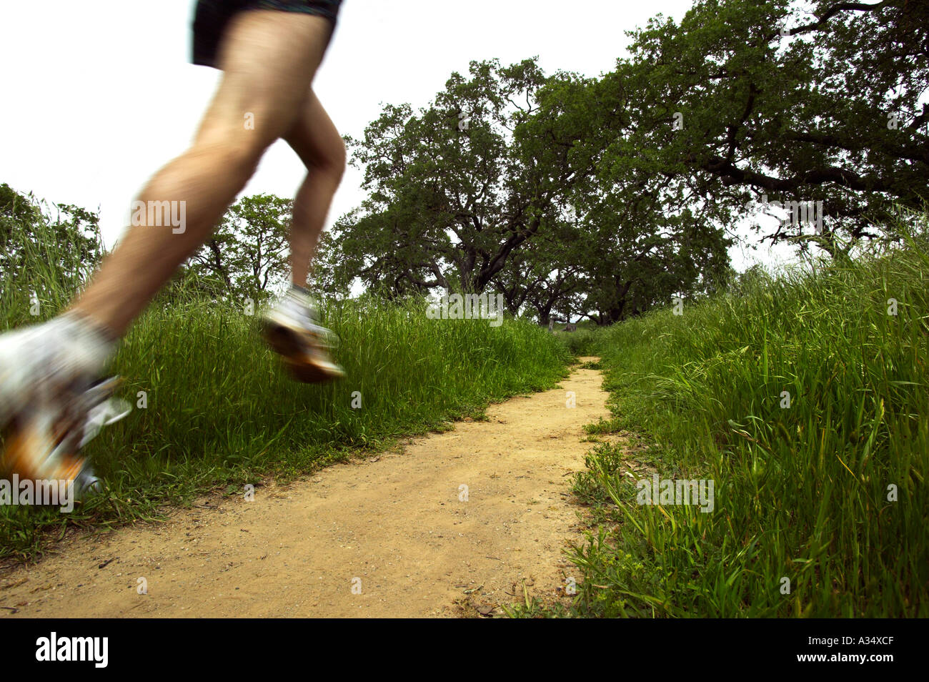 Young man running along path in lush green hills Model Released Image ...