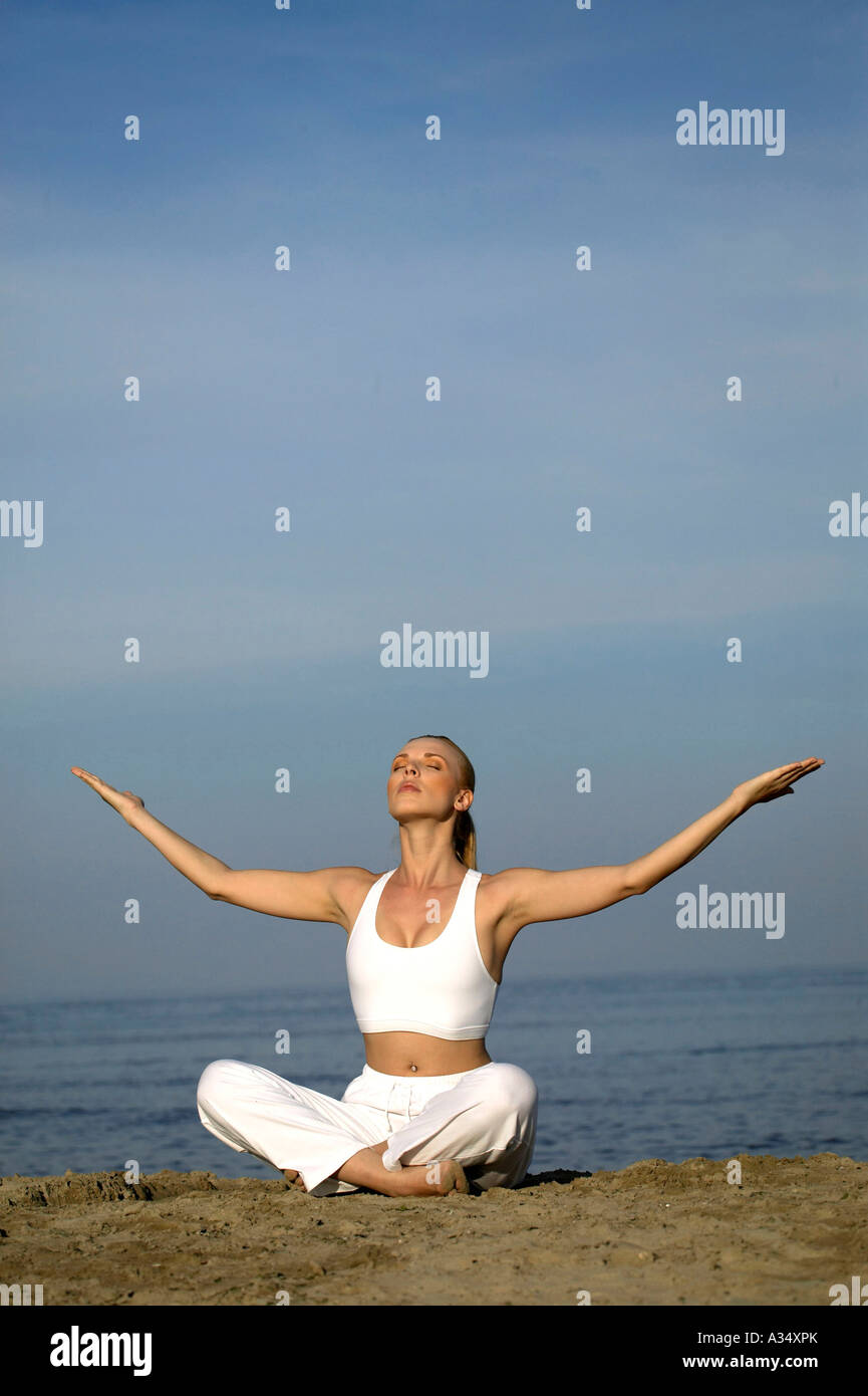 Frau bei einer Yoga Uebung am Strand, woman exercising yoga on the ...