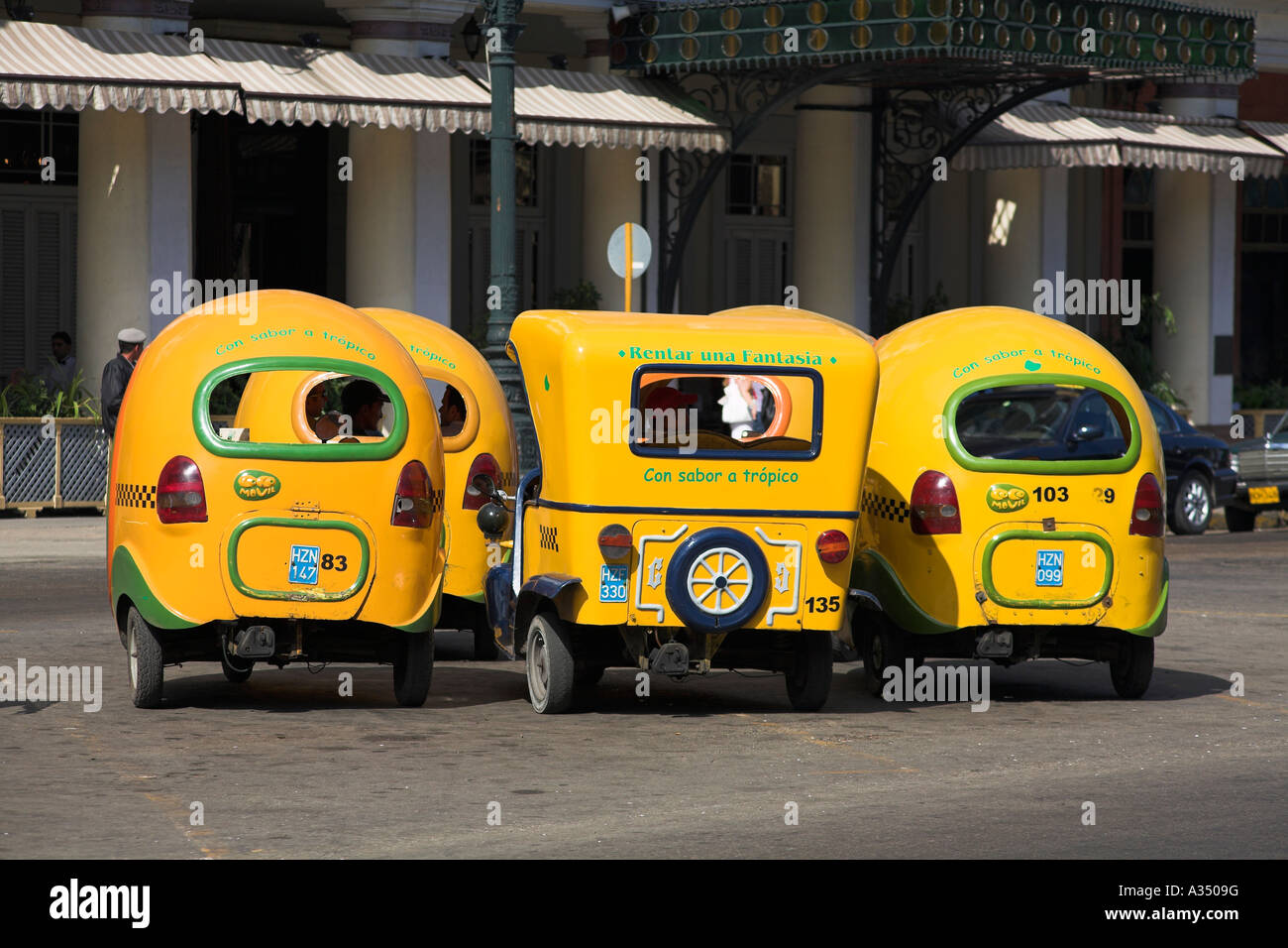 Several yellow three wheeled taxis parked at a taxi rank, Havana, Cuba ...