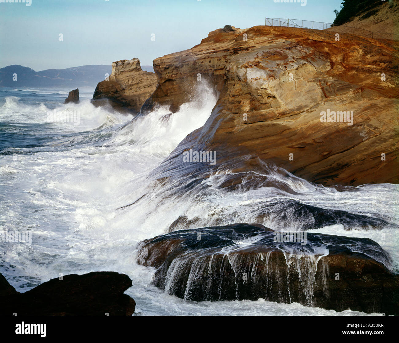 Pacific Ocean surf washes against the rugged cliffs at Cape Kiwanda at ...