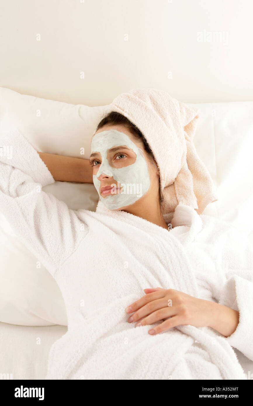 Woman with facial mask lying on bed Stock Photo - Alamy