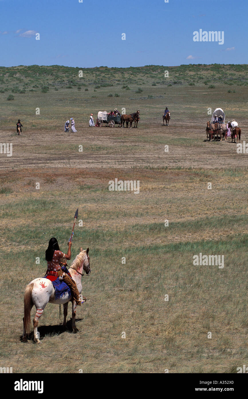 Indian warrior watches settler wagons crossing Western frontier of the ...
