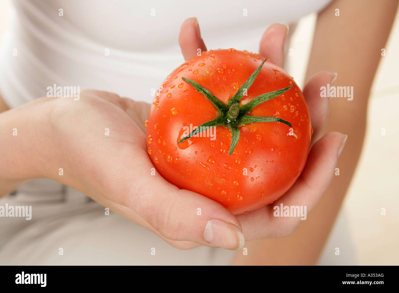 Woman holding tomato Stock Photo - Alamy