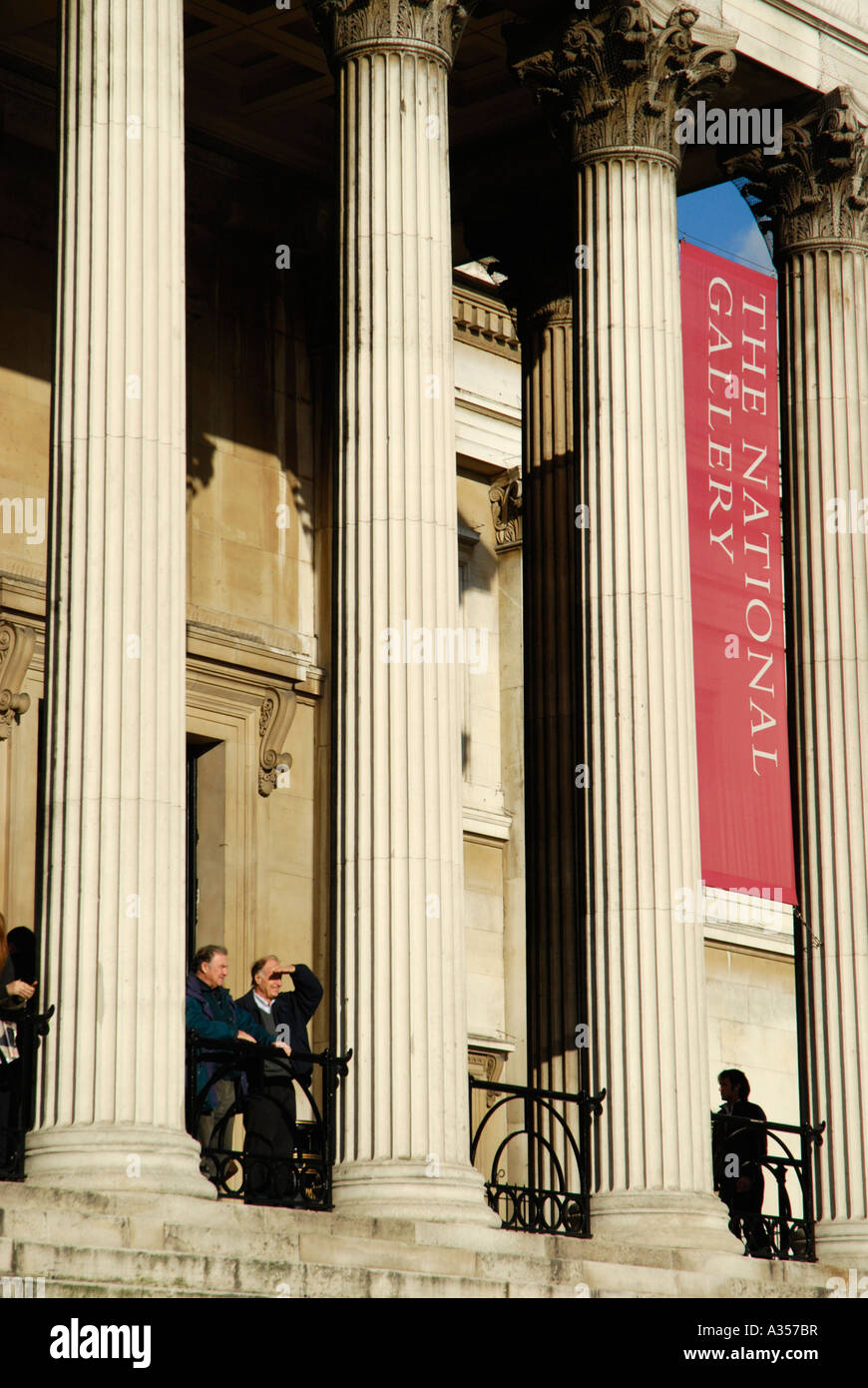 Two middle aged men looking out between columns in front of the ...