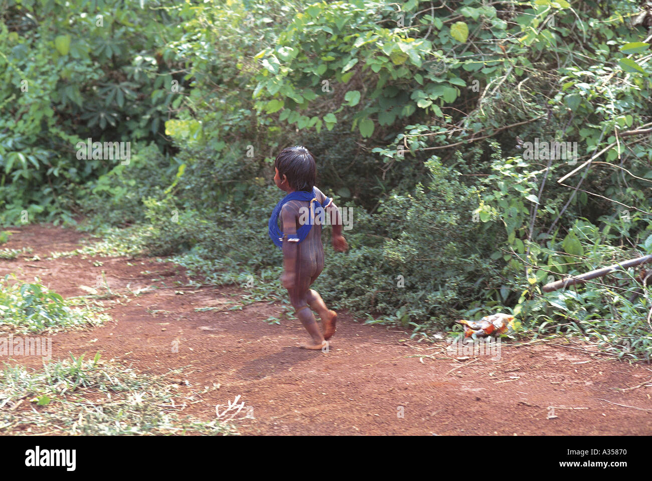 A Ukre village Brazil Kayapo child with black body paint and blue beads ...