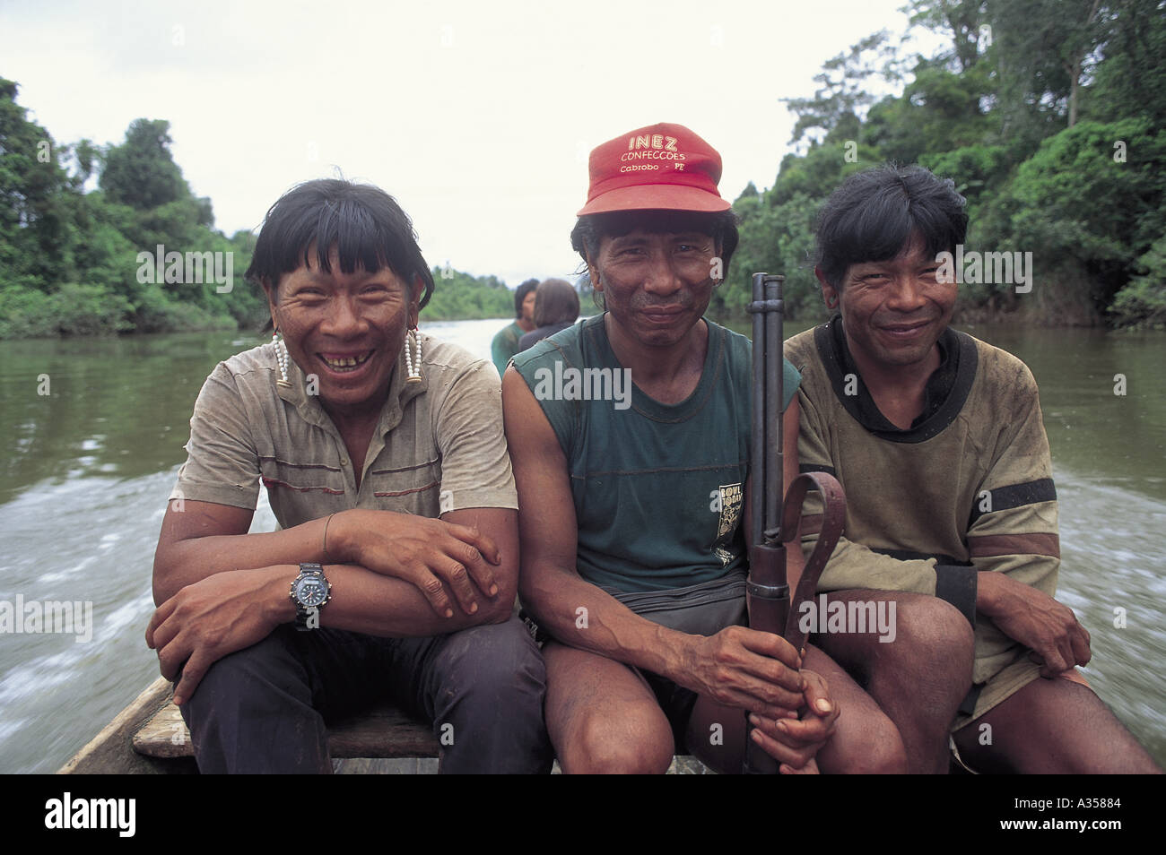 A Ukre Village Brazil Three smiling Kayapo men with a rifle in a canoe ...