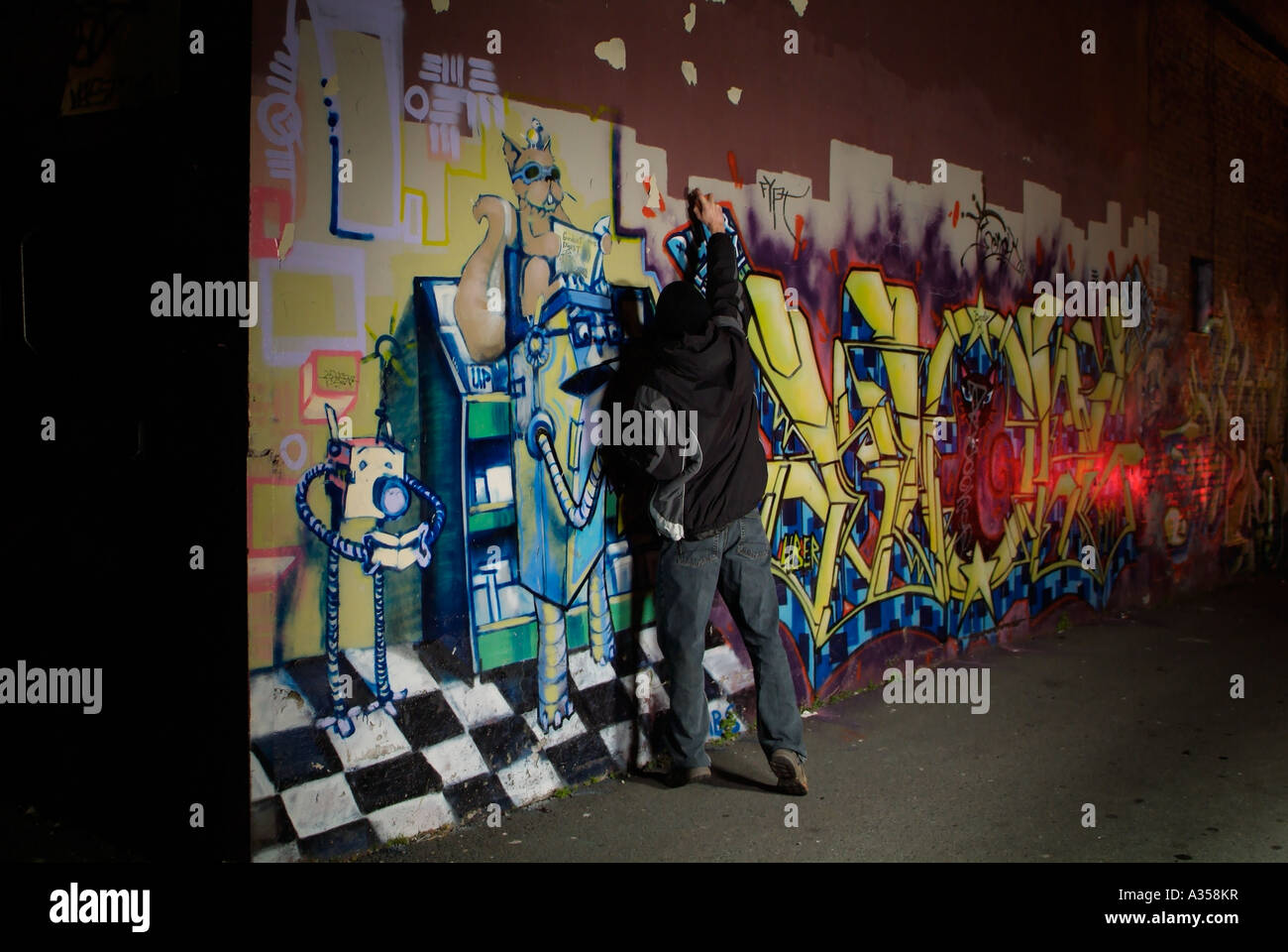A graffiti artist getting caught painting on an alley wall at night ...