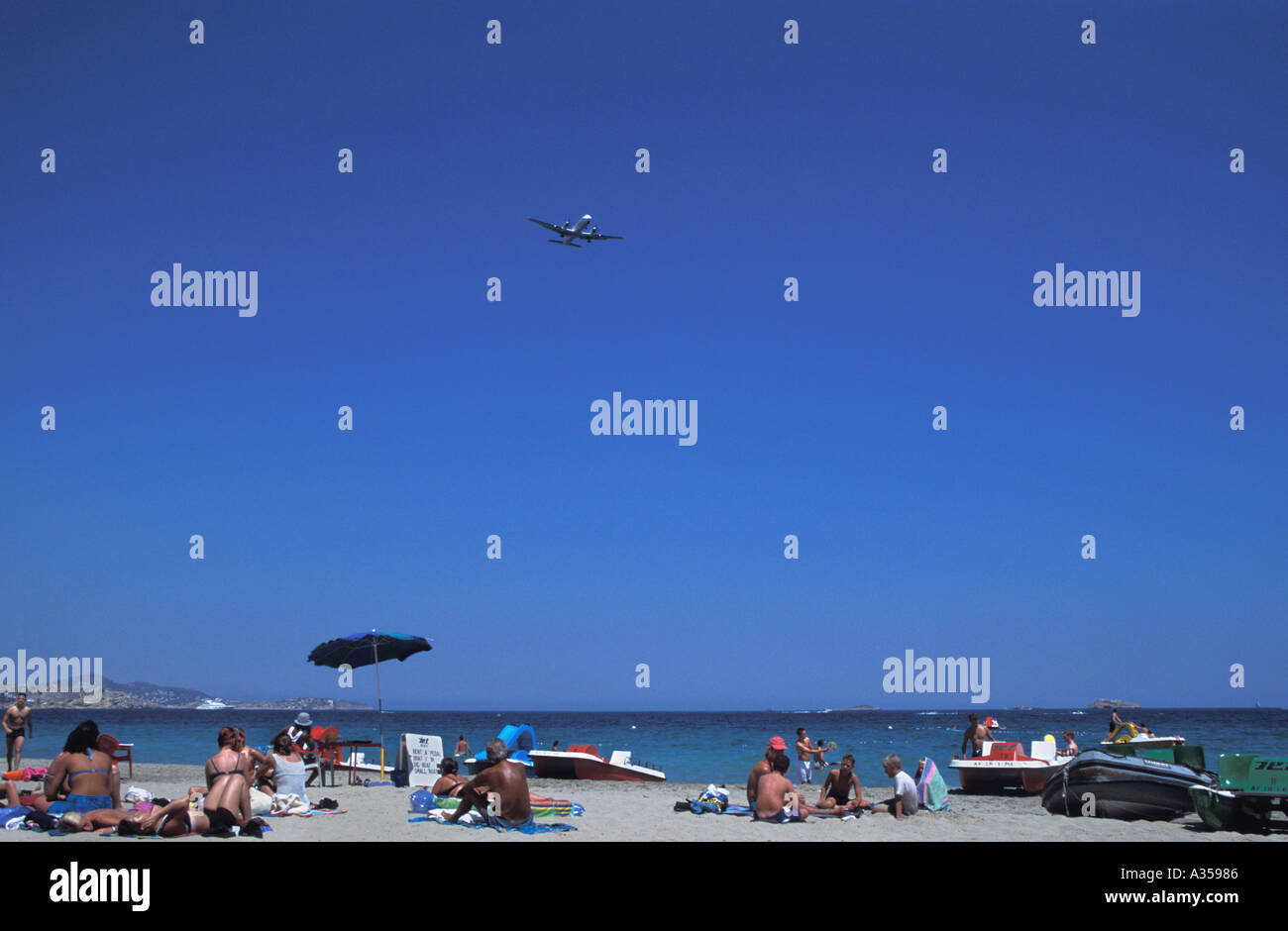 Plane flying over beach at Playa d'en Bossa Ibiza Spain Stock Photo - Alamy
