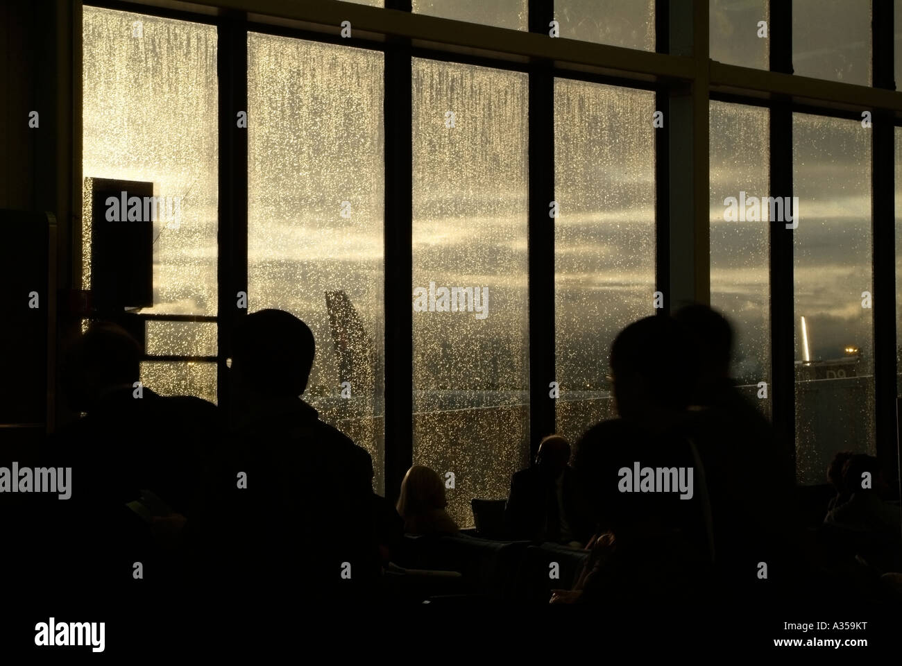 Waiting in an airport lobby. Raining outside Stock Photo - Alamy