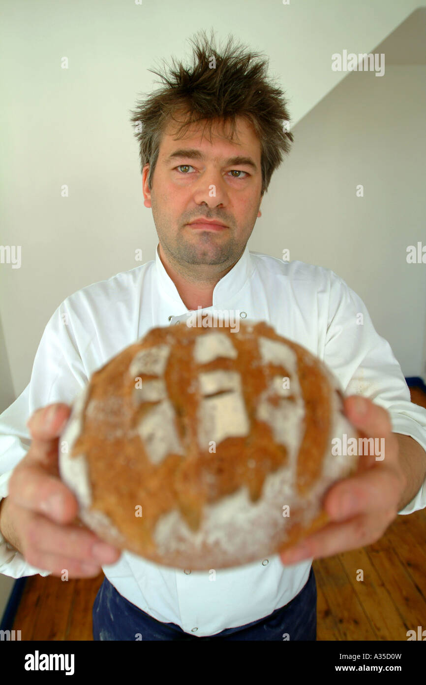 Baker holds a freshly baked loaf of bread Stock Photo - Alamy