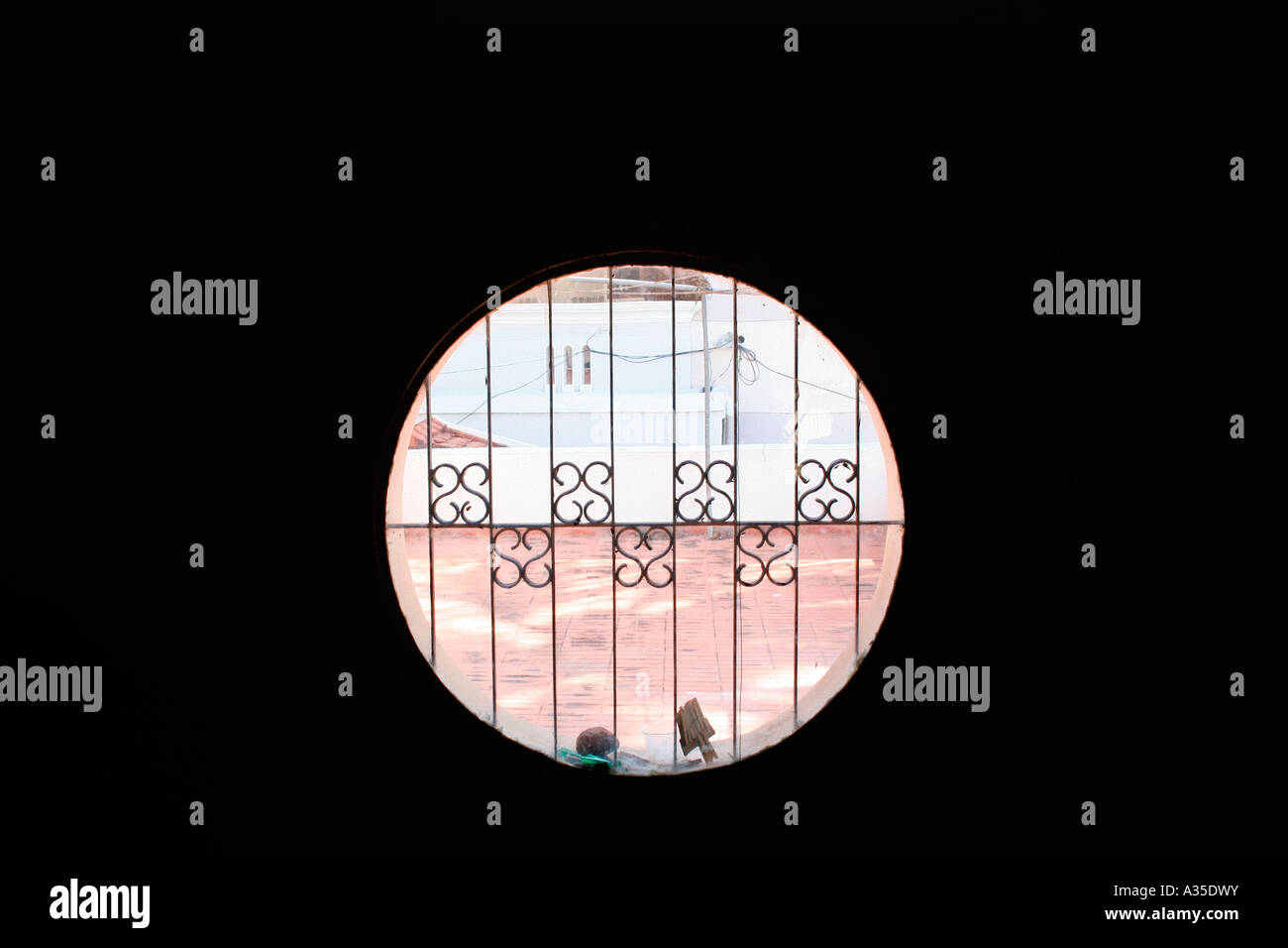 hole in the wall circular glass window with a patterned grille viewed ...
