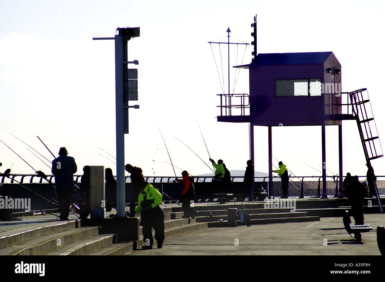 fishermen and pink building on the barrage cardiff bay south wales uk ...