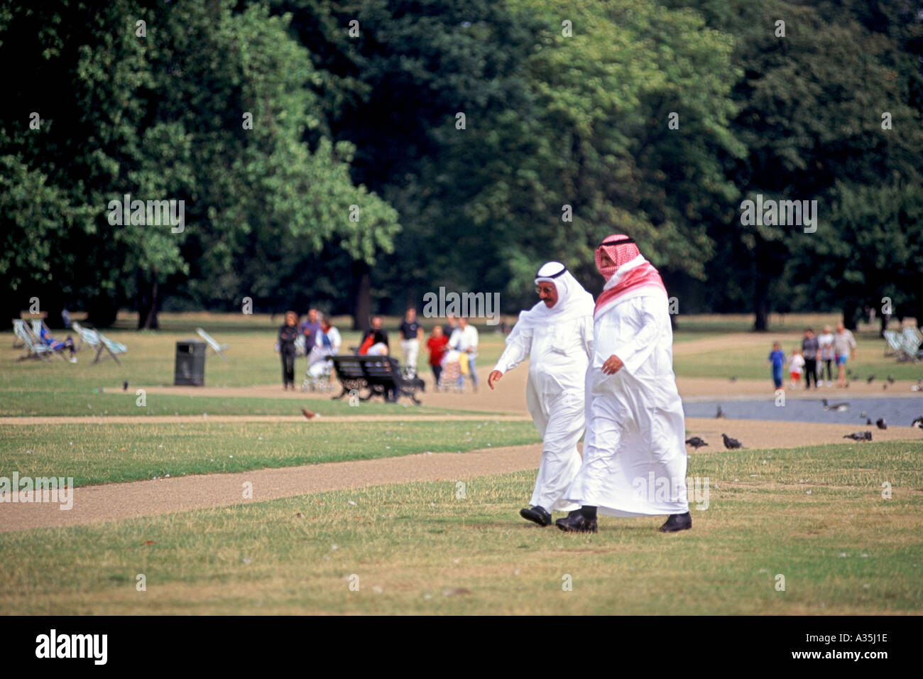 Two Arab men in traditional outfits walking through Hyde Park in London ...
