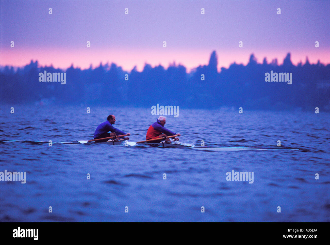 Two middle aged men row a two man shell in rough water at dawn Lake ...
