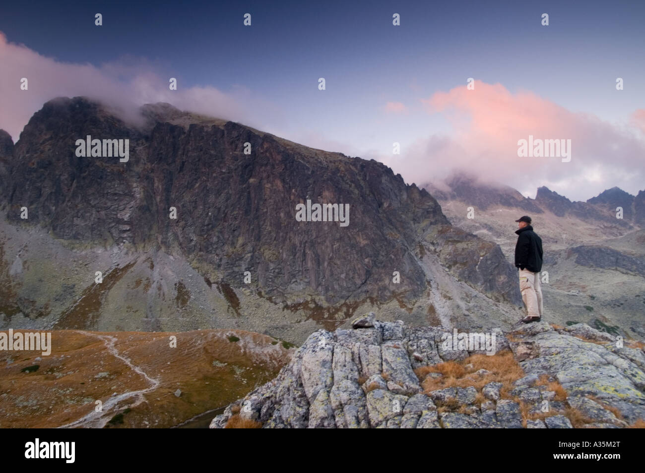 A lonely tourist watching the sunset in the mountains Stock Photo - Alamy