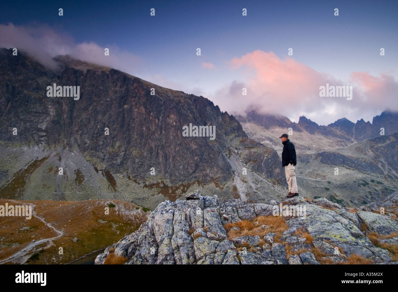 A lonely tourist watching the sunset in the mountains Stock Photo - Alamy