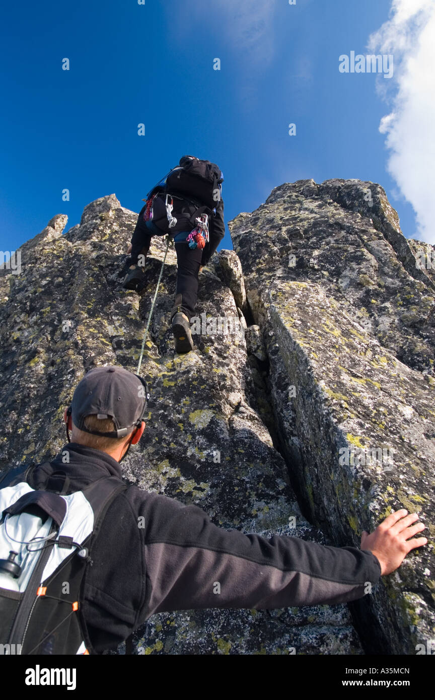 two climbers on the rock, leading climber reaching for the summit Stock ...