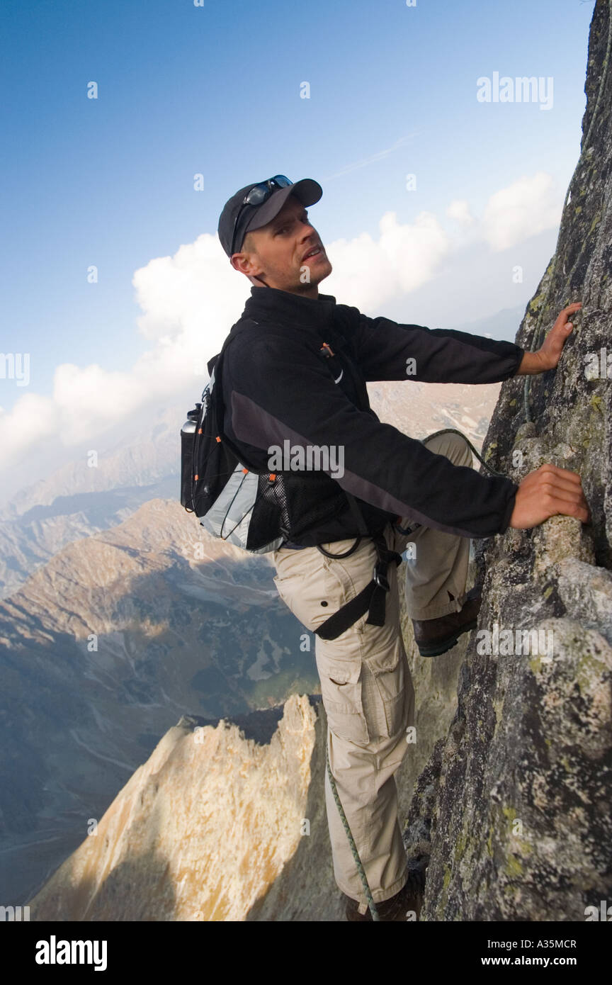 A handsome young climber holding onto safe grips on the rock Stock ...