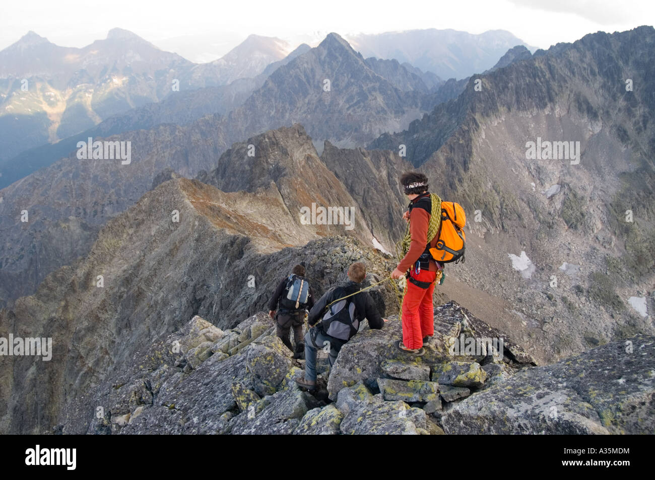 A mountain guide is instructing two clients on a descent route Stock ...