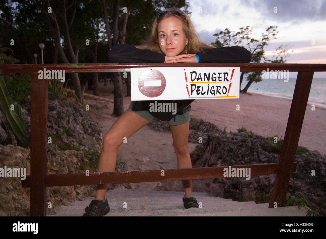 a young woman ignoring the danger sign Stock Photo - Alamy