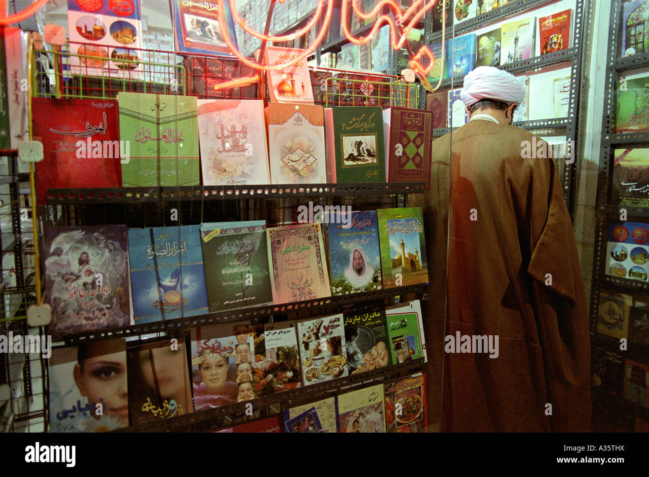 A mullah, or imam, browses religious books in a shop in Qom, Iran Stock ...