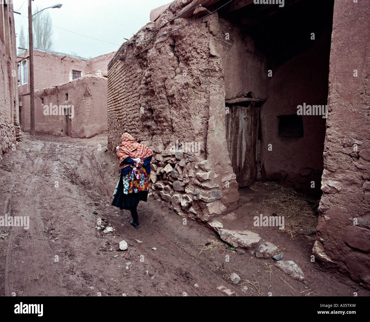 An elderly woman wearing traditional Zoroastrian clothing walks in the ...