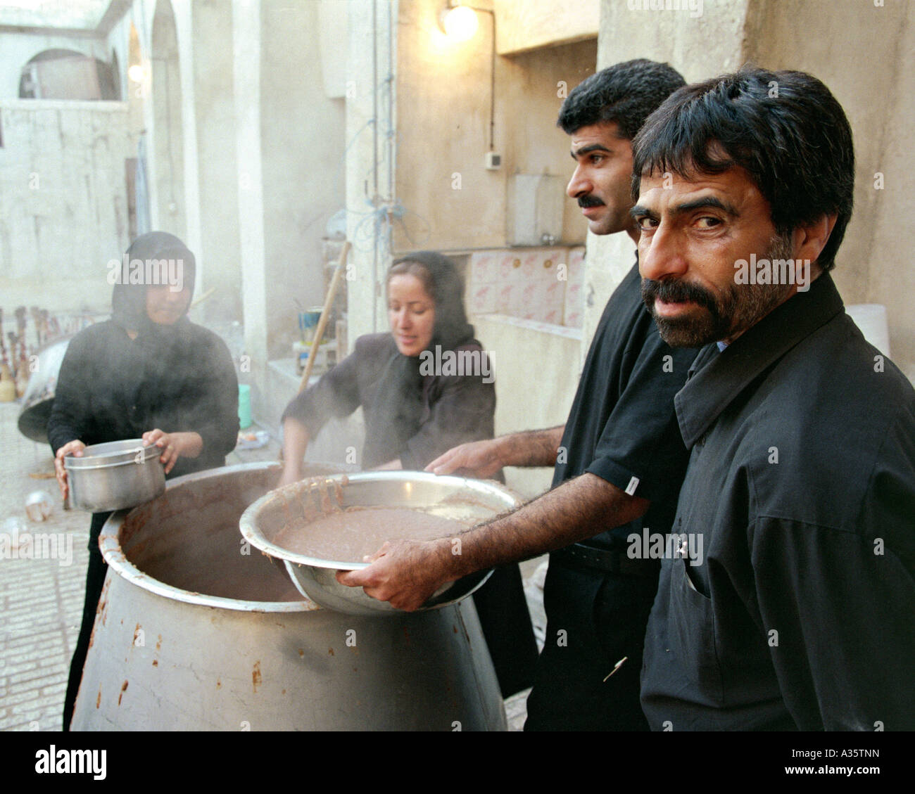Men and women preparing a ritual soup, called abgusht, during Ashura ...