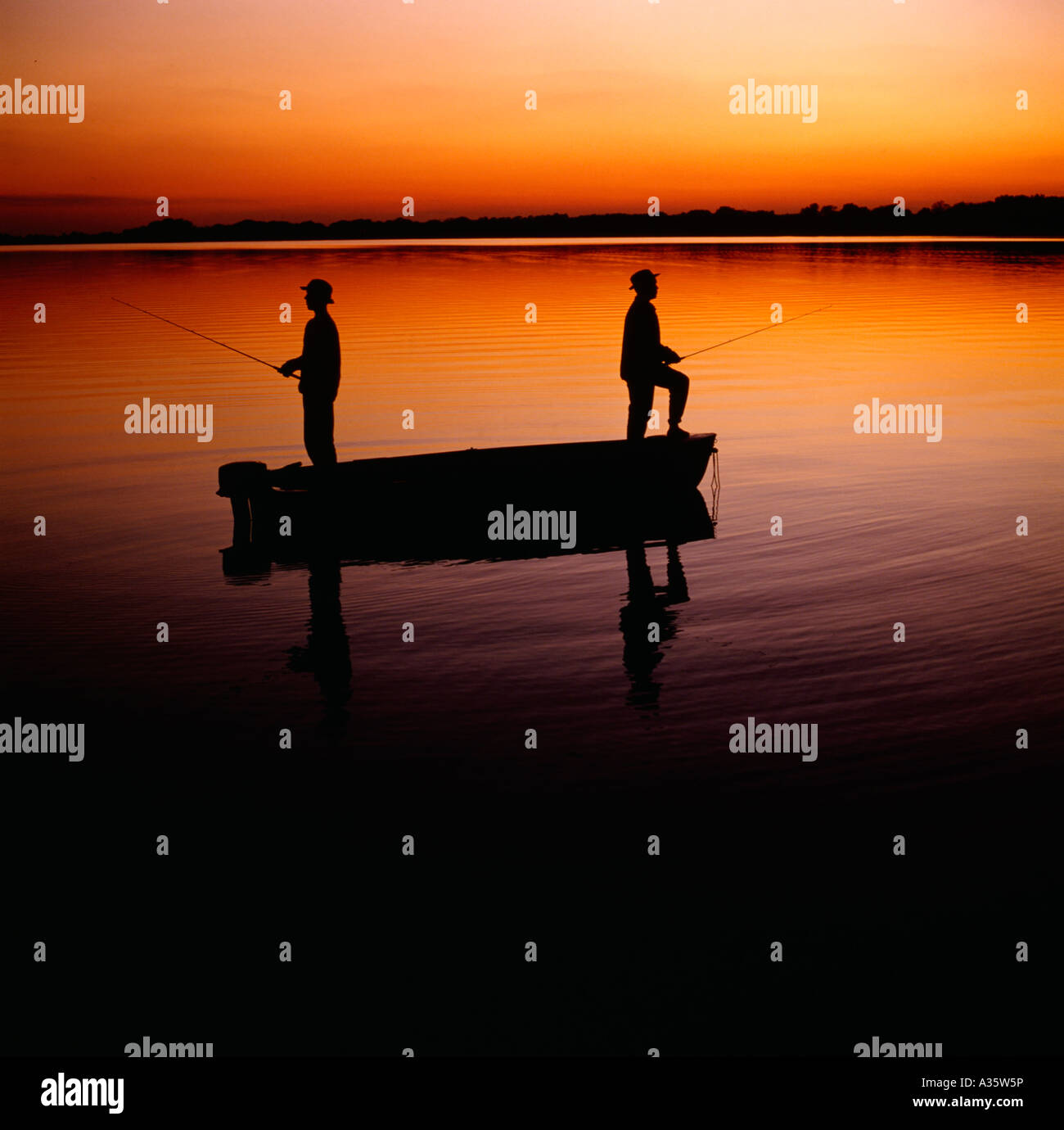 Men fishing at sunset Stock Photo - Alamy
