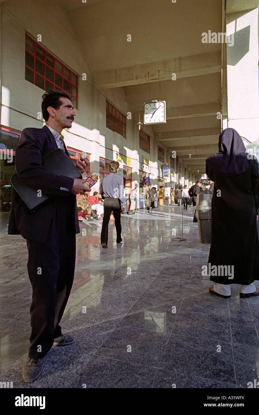 A man enjoys a snack while awaiting his bus at the station. Shiraz ...