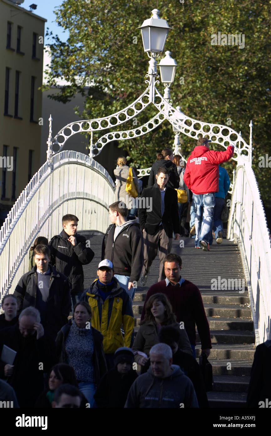 people crossing the hapenny ha penny bridge over the river liffey in ...