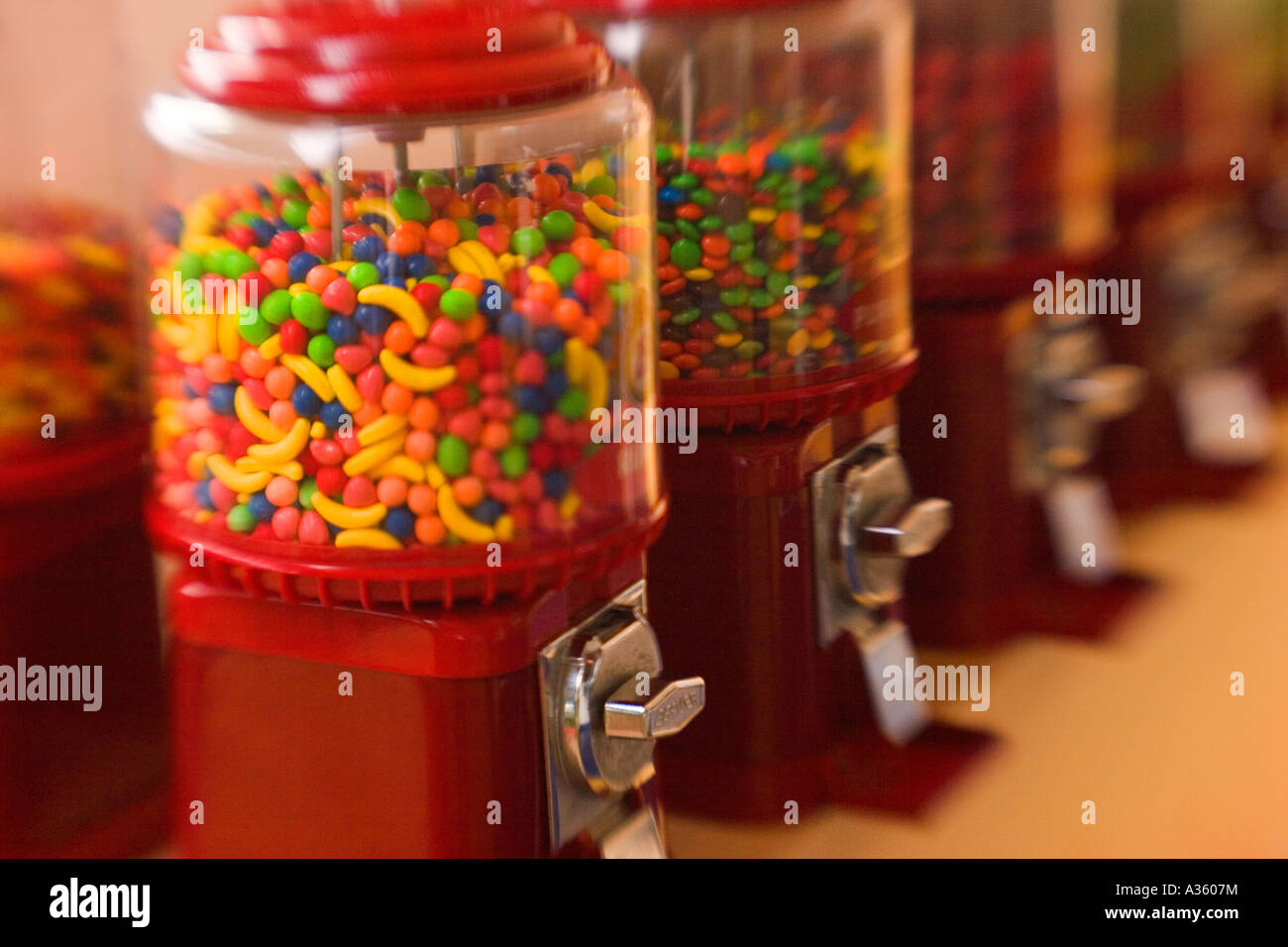 A row of colorful gumball machines display their tasty candy and gum ...