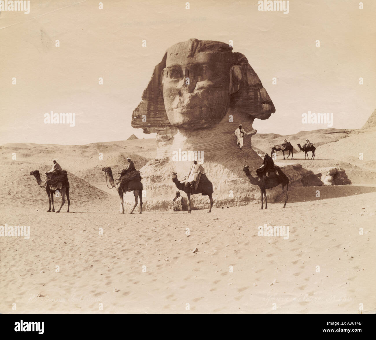 The head of the Sphinx rising from the sand with camel riders in the ...