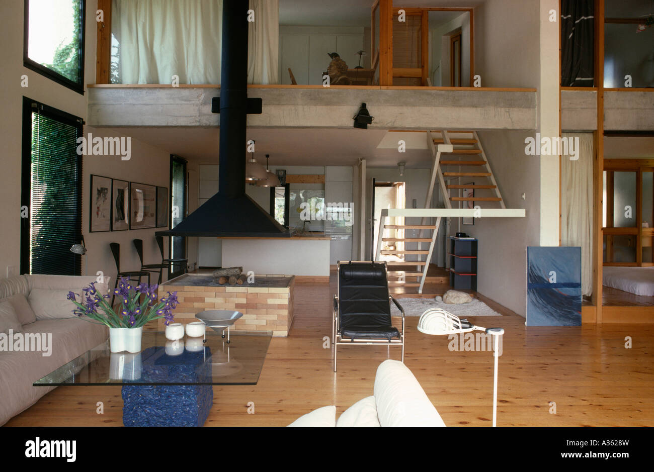 Openplan modern sittingroom with gallery and wooden floor Stock Photo ...