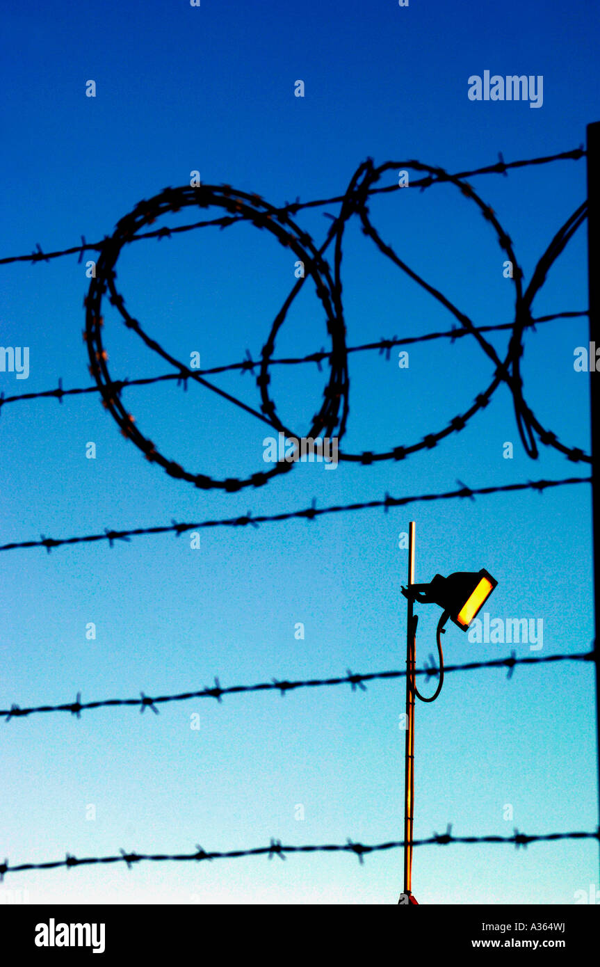Barbed Wire Fencing & A Security Light Set Against A Clear Blue Sky ...