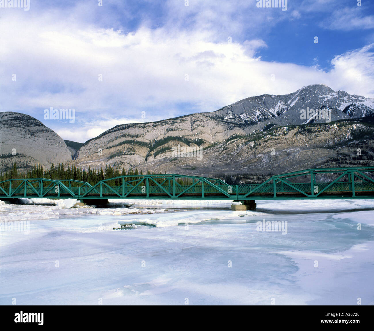 The frozen Snaring River with green bridge Jasper National Park Alberta ...
