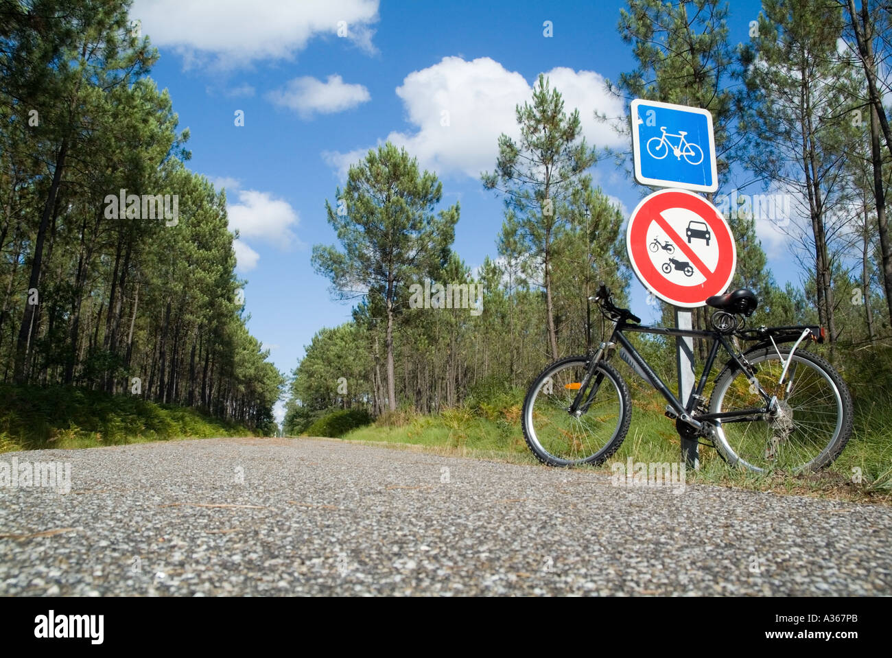 Bicycle parked against a road signs on a bicycle track passing through ...