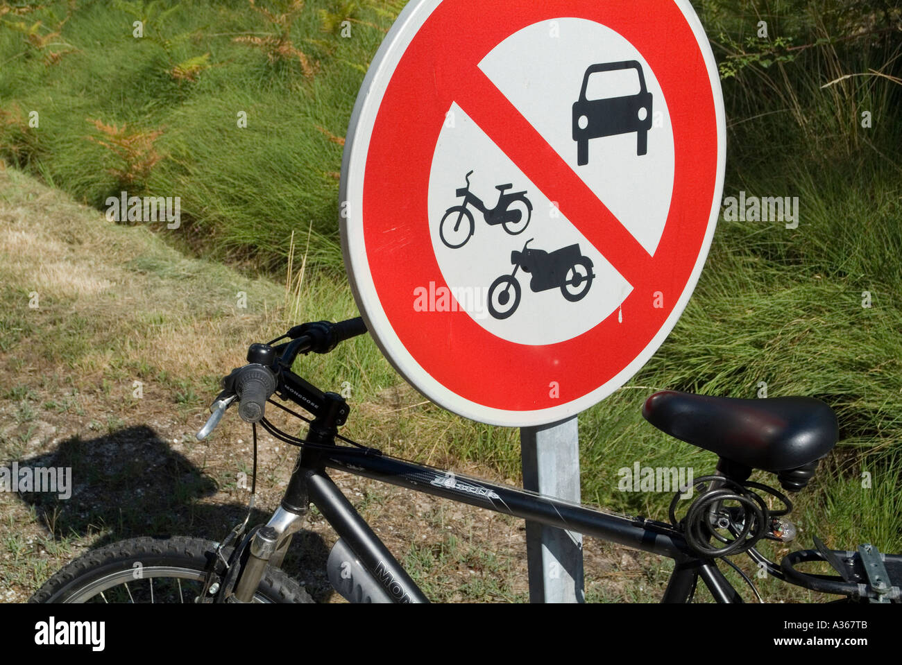 Bicycle parked against a road sign post Stock Photo - Alamy