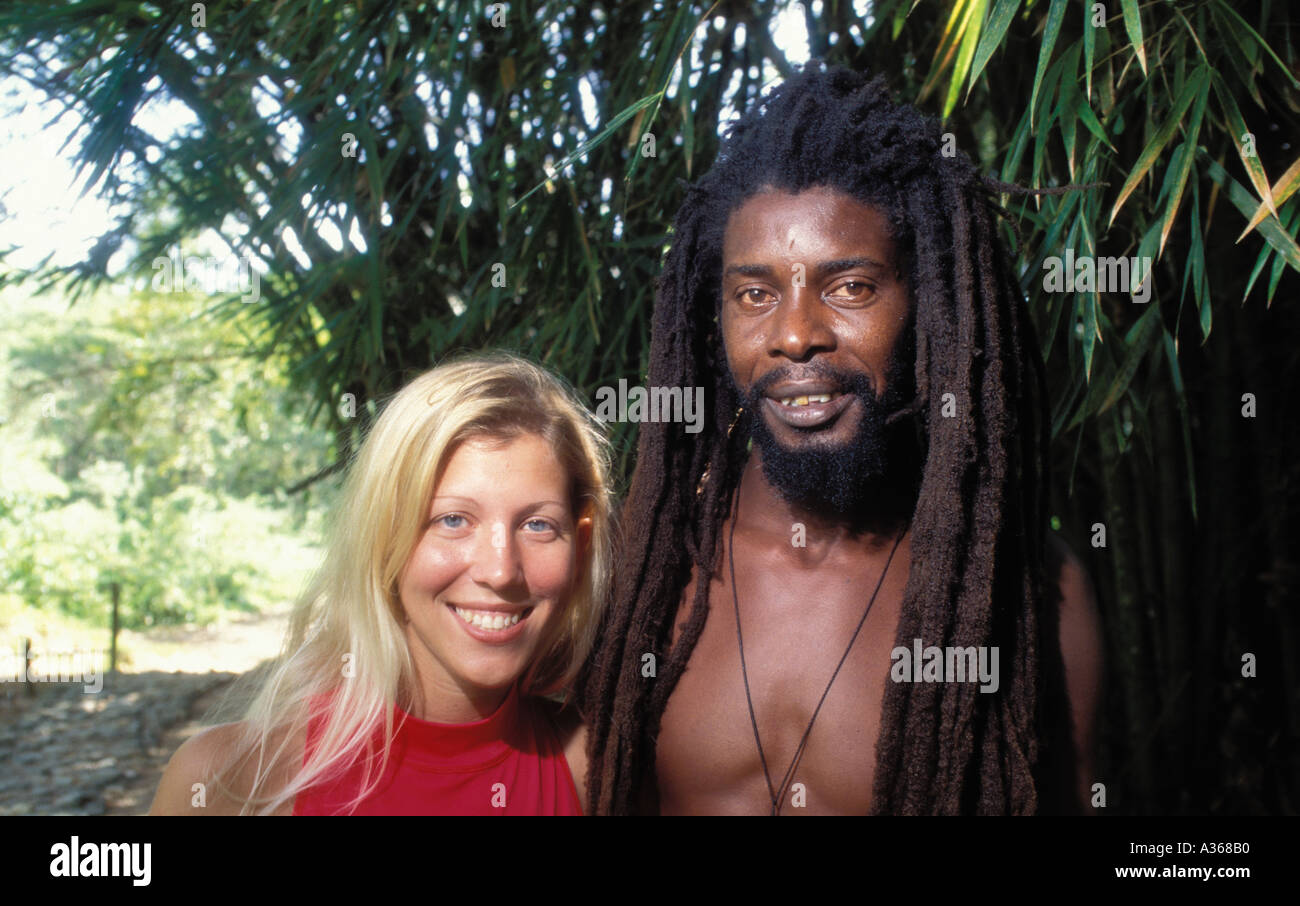 A pretty blonde woman with blue eyes stands next to a Trinidad native ...