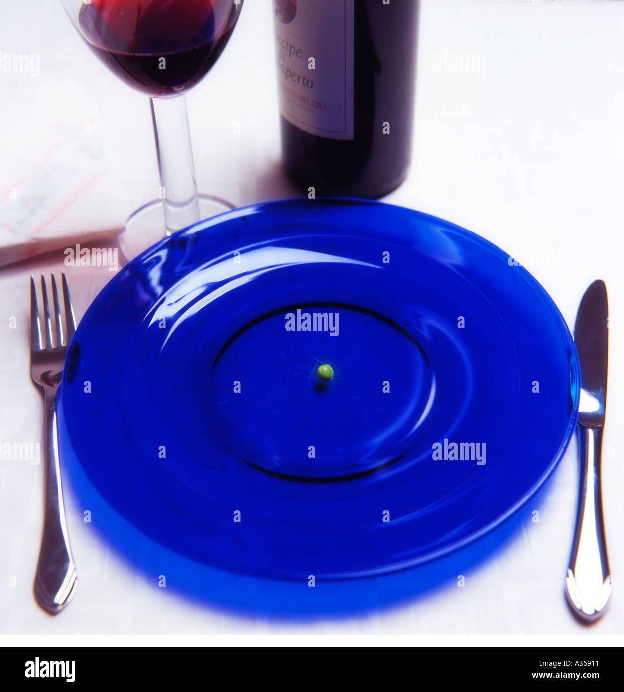 Empty plate with a single pea in the middle illustrating the concept of ...