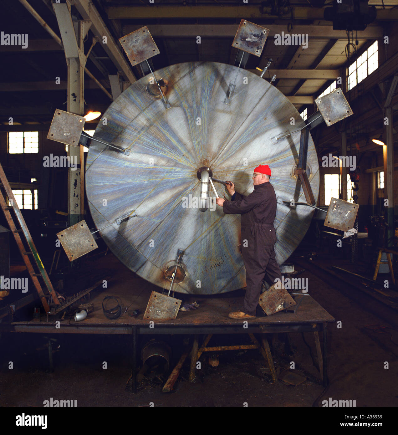 worker in old fashioned boiler factory with red hat Stock Photo - Alamy