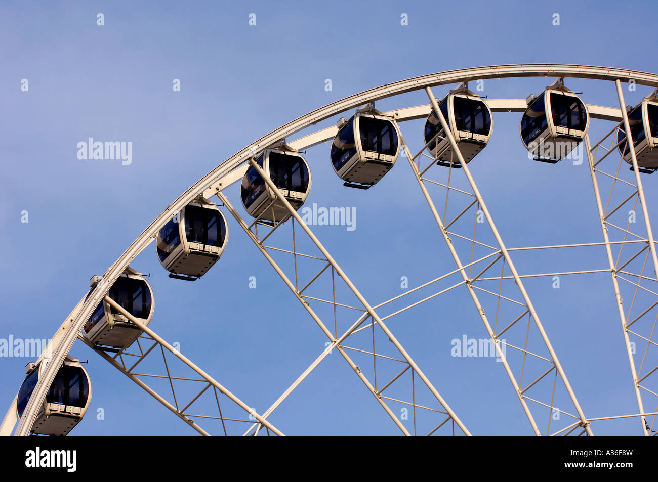 Passenger capsules on an observation wheel seen against a blue sky ...